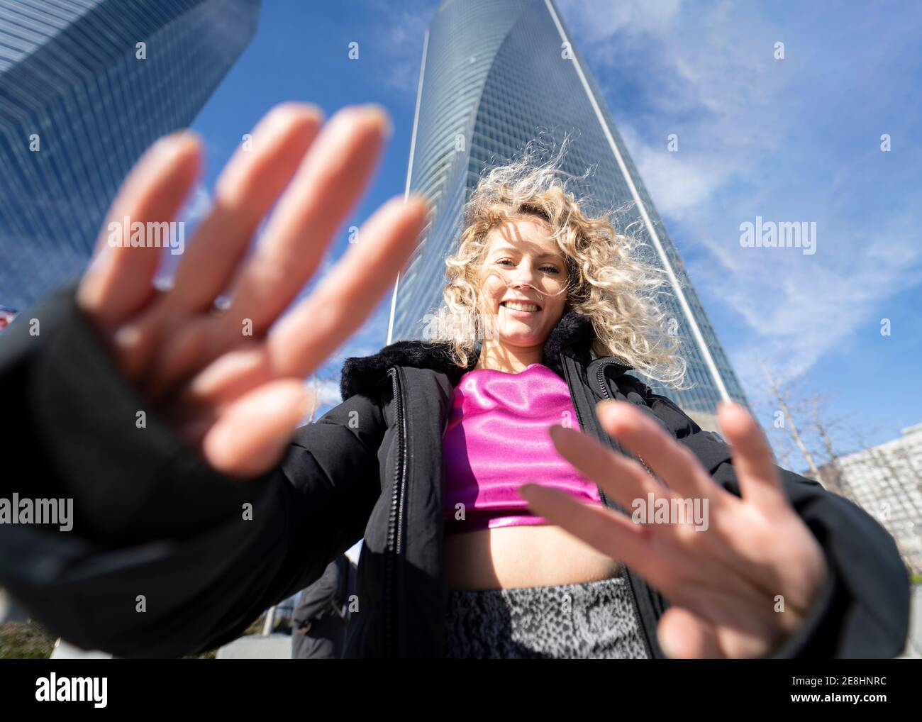 From below of cheerful female with blonde curly hair and in fancy ...