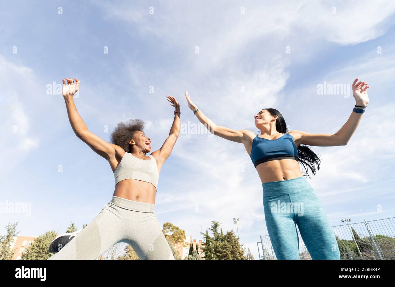 From below of delighted multiethnic female athletes in sportswear in ...