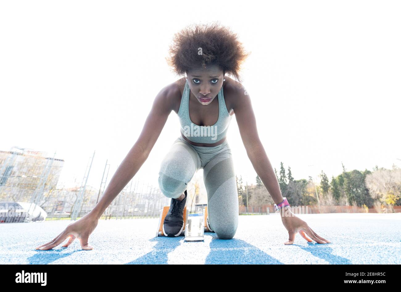 From below of African American female runner in starting blocks ...