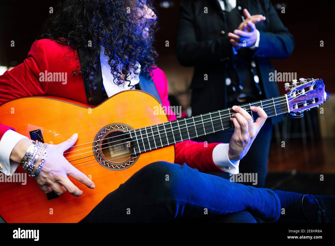 Ethnic male musician holding chord on strings of guitar while playing ...