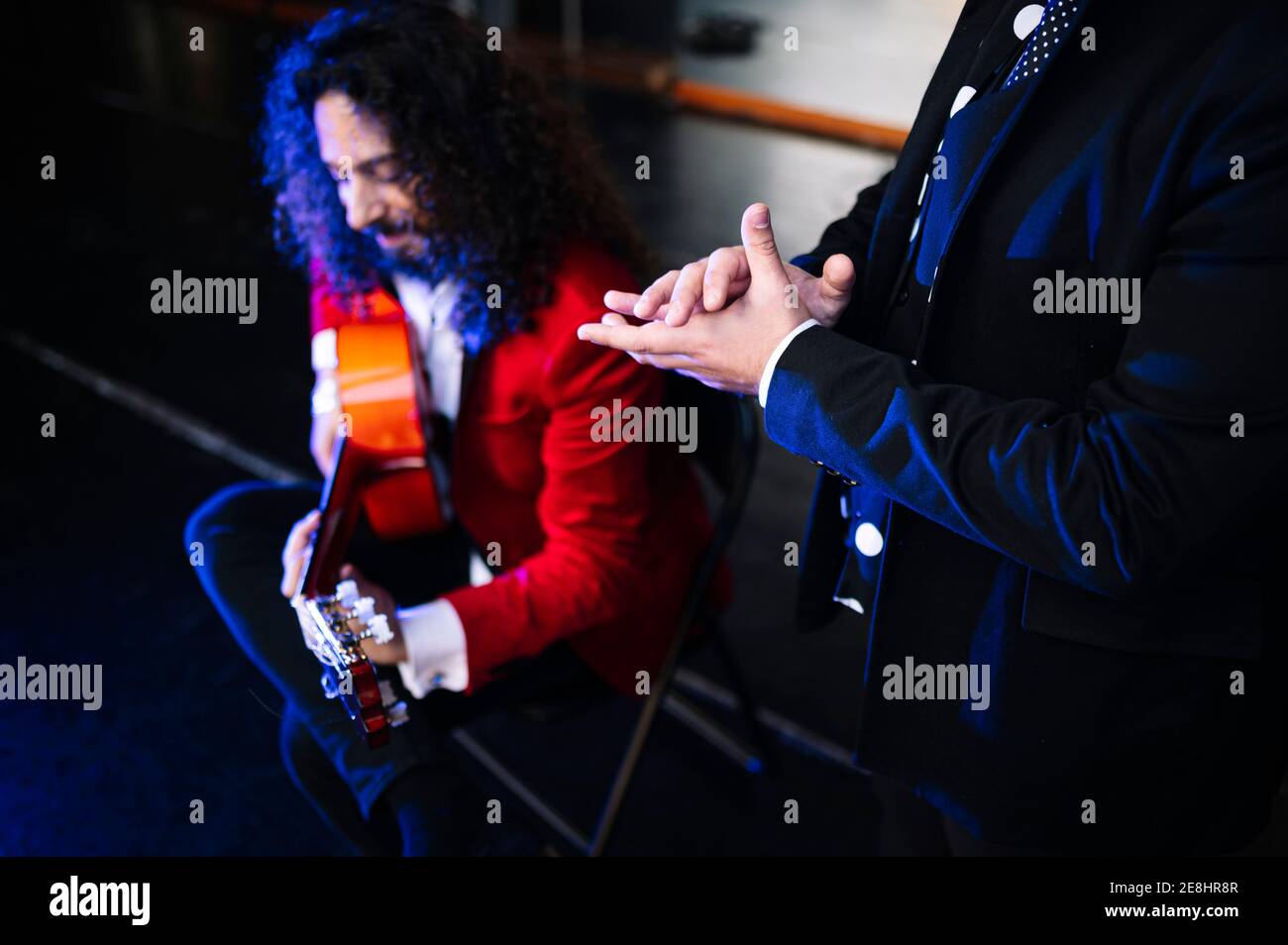 Ethnic male musician holding chord on strings of guitar while playing ...