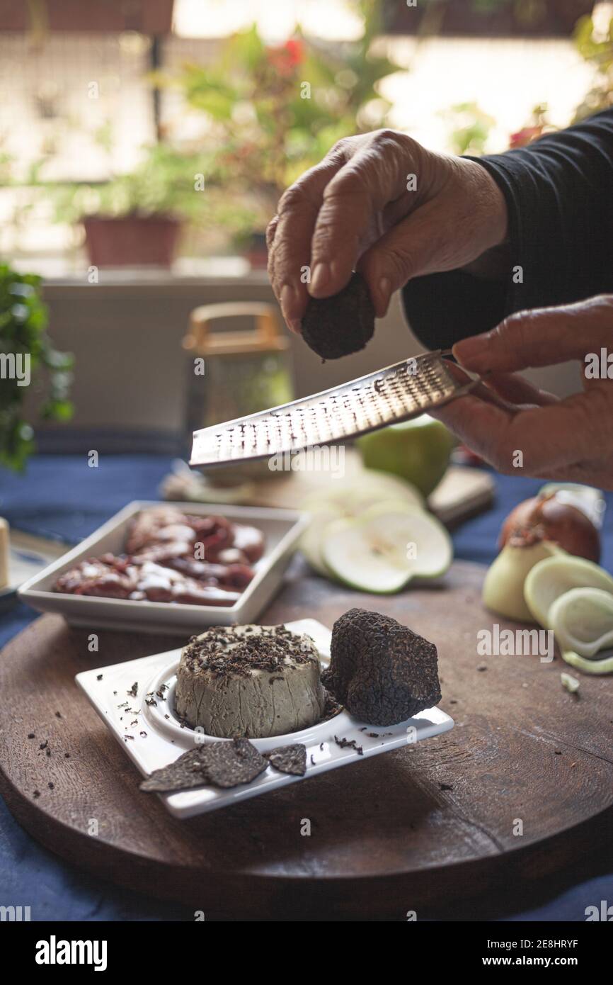 Crop unrecognizable chef sprinkling soft cheese with truffle using ...