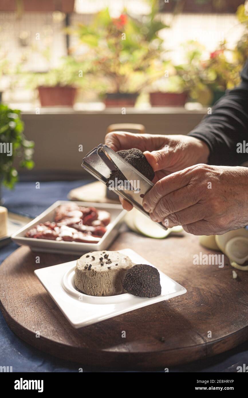 Crop unrecognizable chef sprinkling soft cheese with truffle using ...