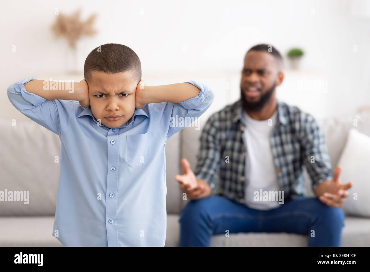 Black Boy Covering Ears While Angry Father Shouting At Home Stock Photo ...