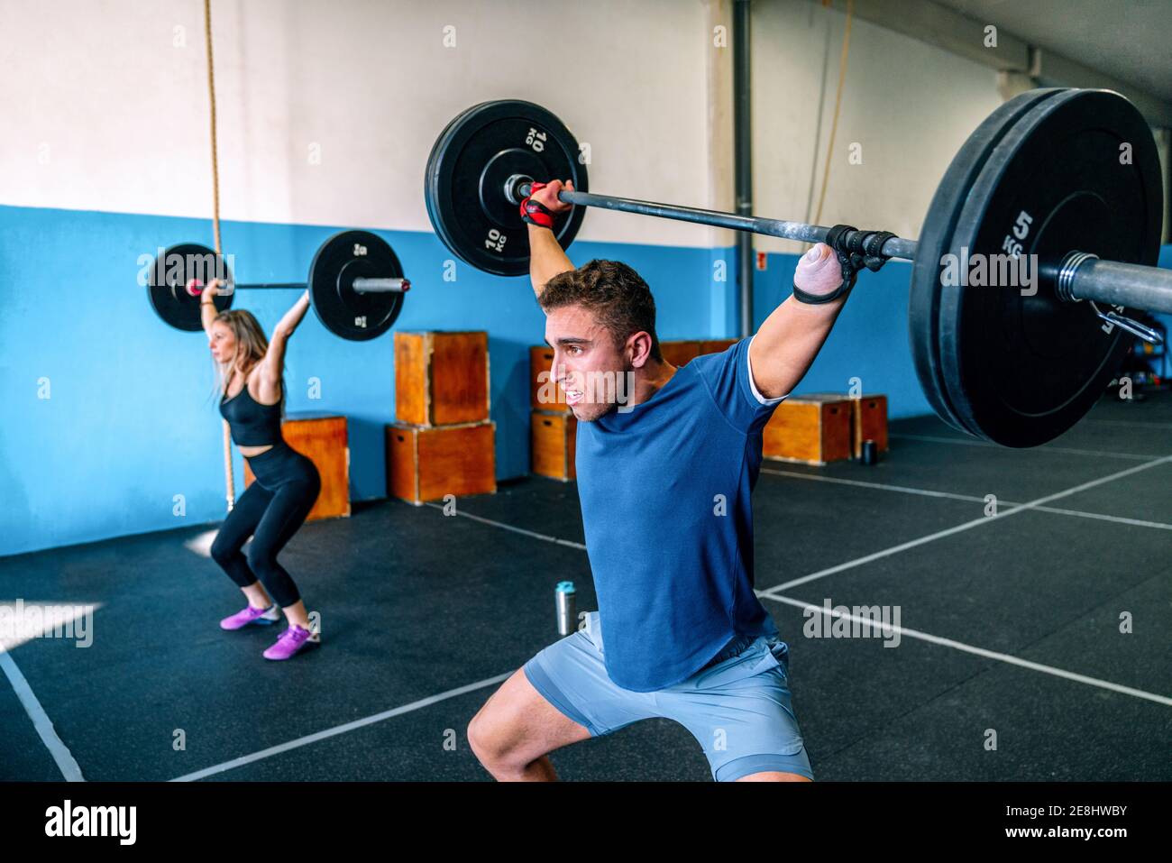 Powerful sportsWoman with handicapped male athlete lifting heavy ...