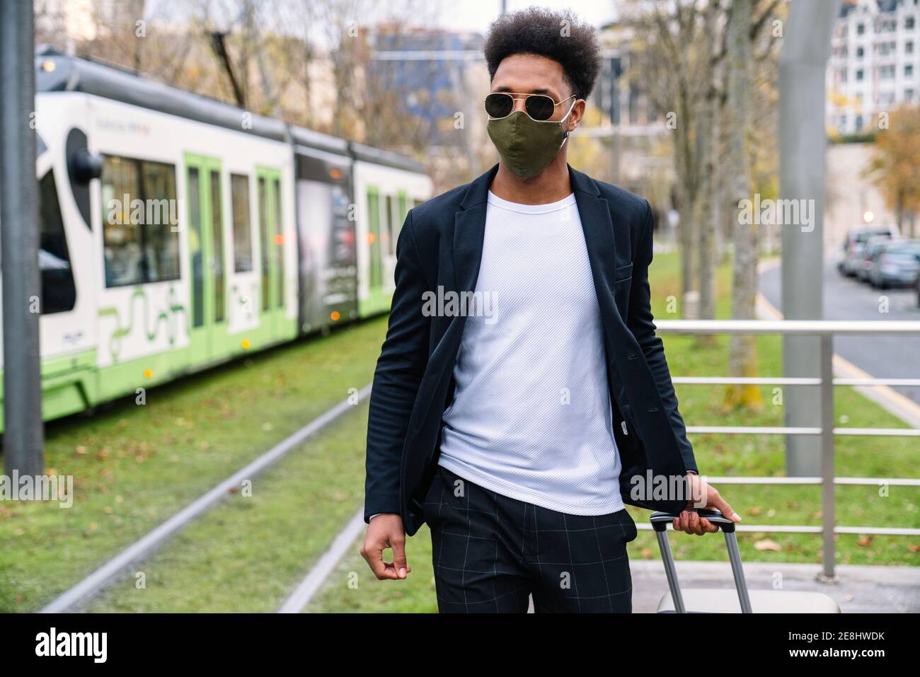 Faceless female baker breaking raw chicken egg into sifted flour pile ...