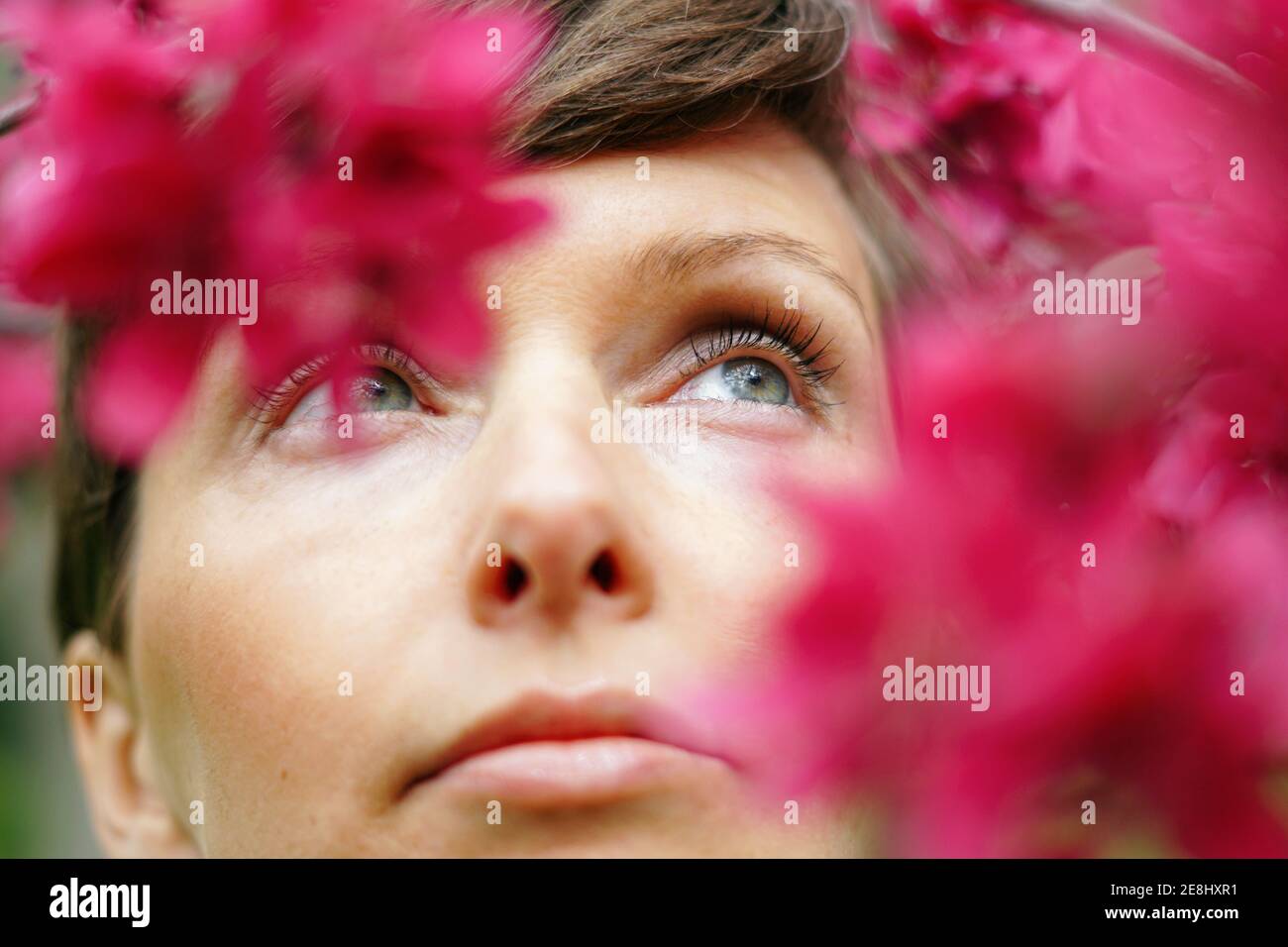 Crop pensive adult female with short hair recreating in green garden ...