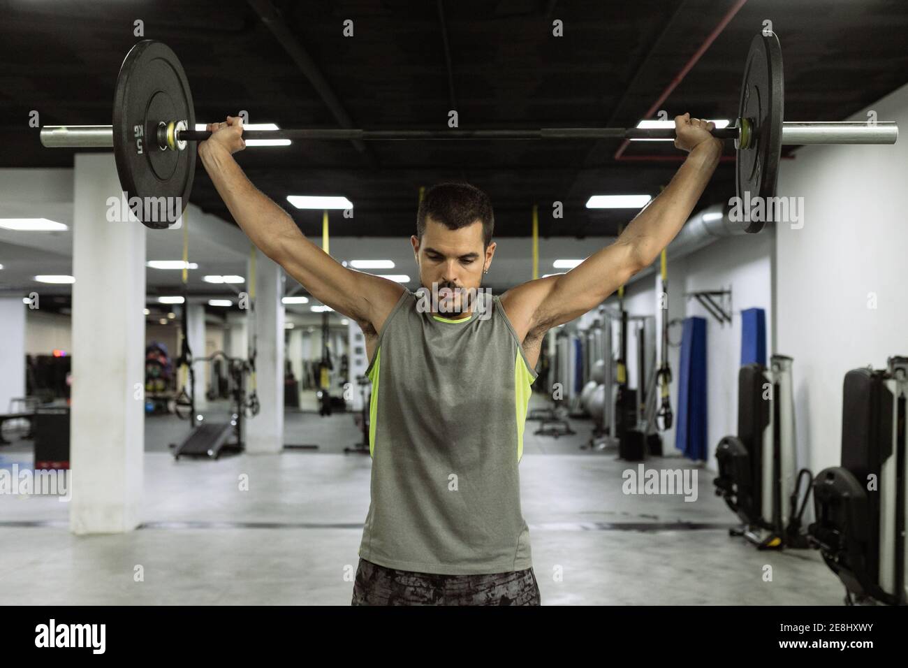 Full body of strong young muscular male athlete in activewear lifting ...