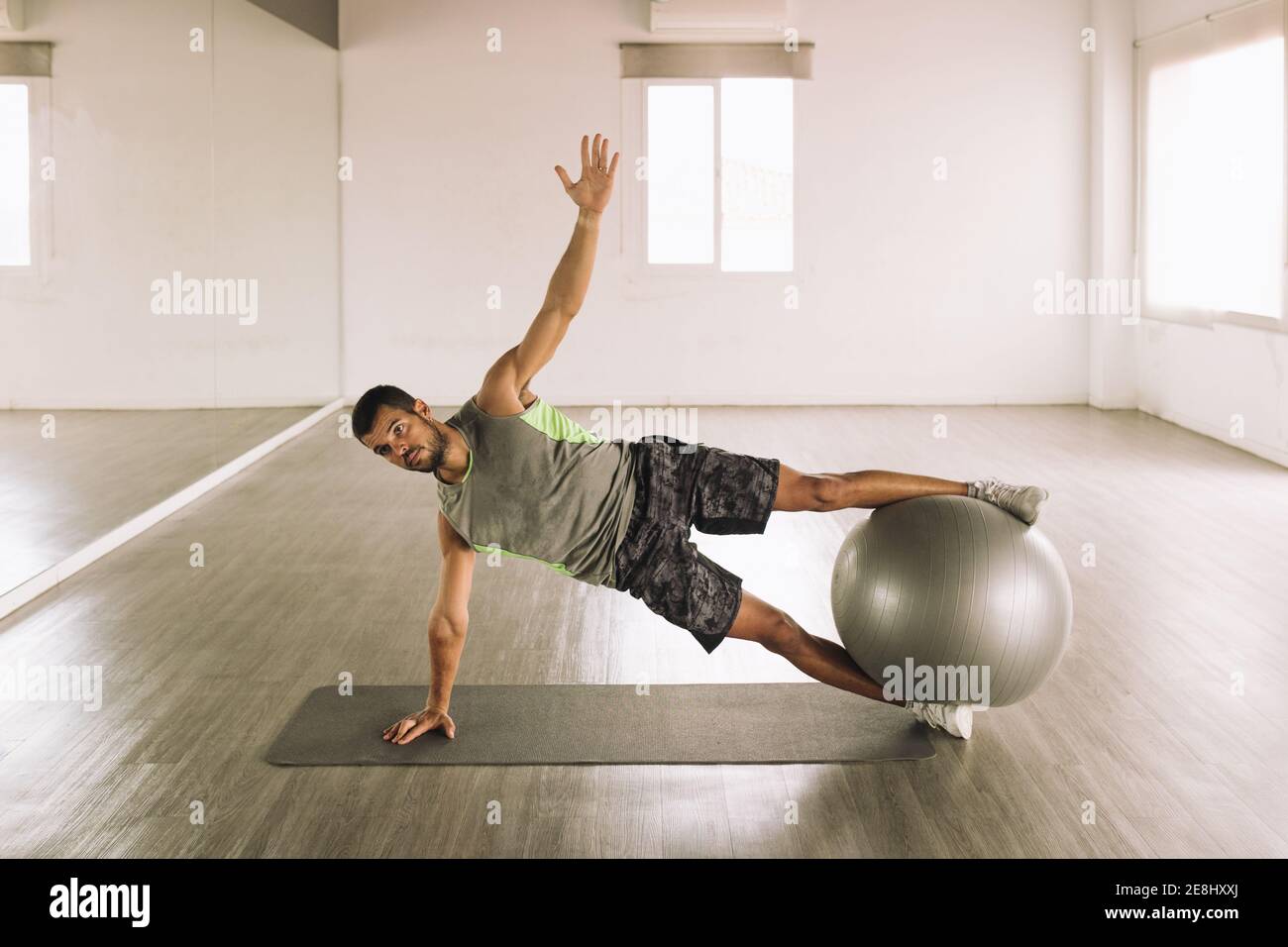 Full length of strong muscular sportsman doing Side Star Plank on fit ...