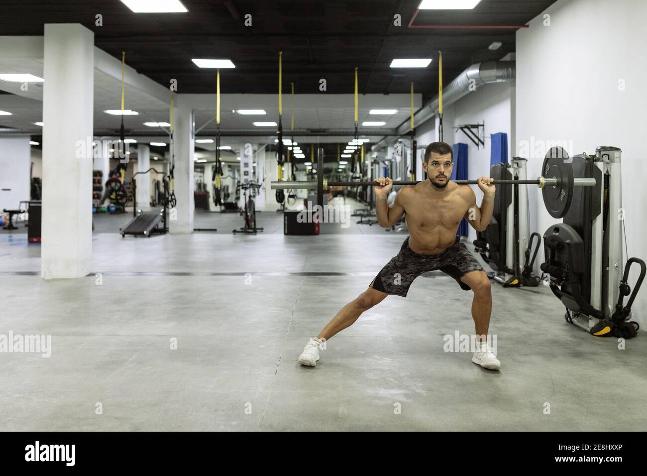 Full body of strong young muscular male athlete in activewear lifting ...
