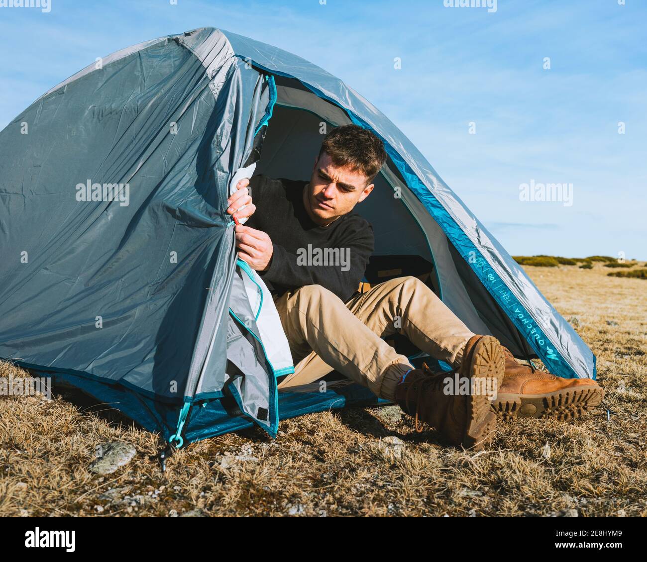 Full body of trendy young male traveler in stylish outfit sitting in ...