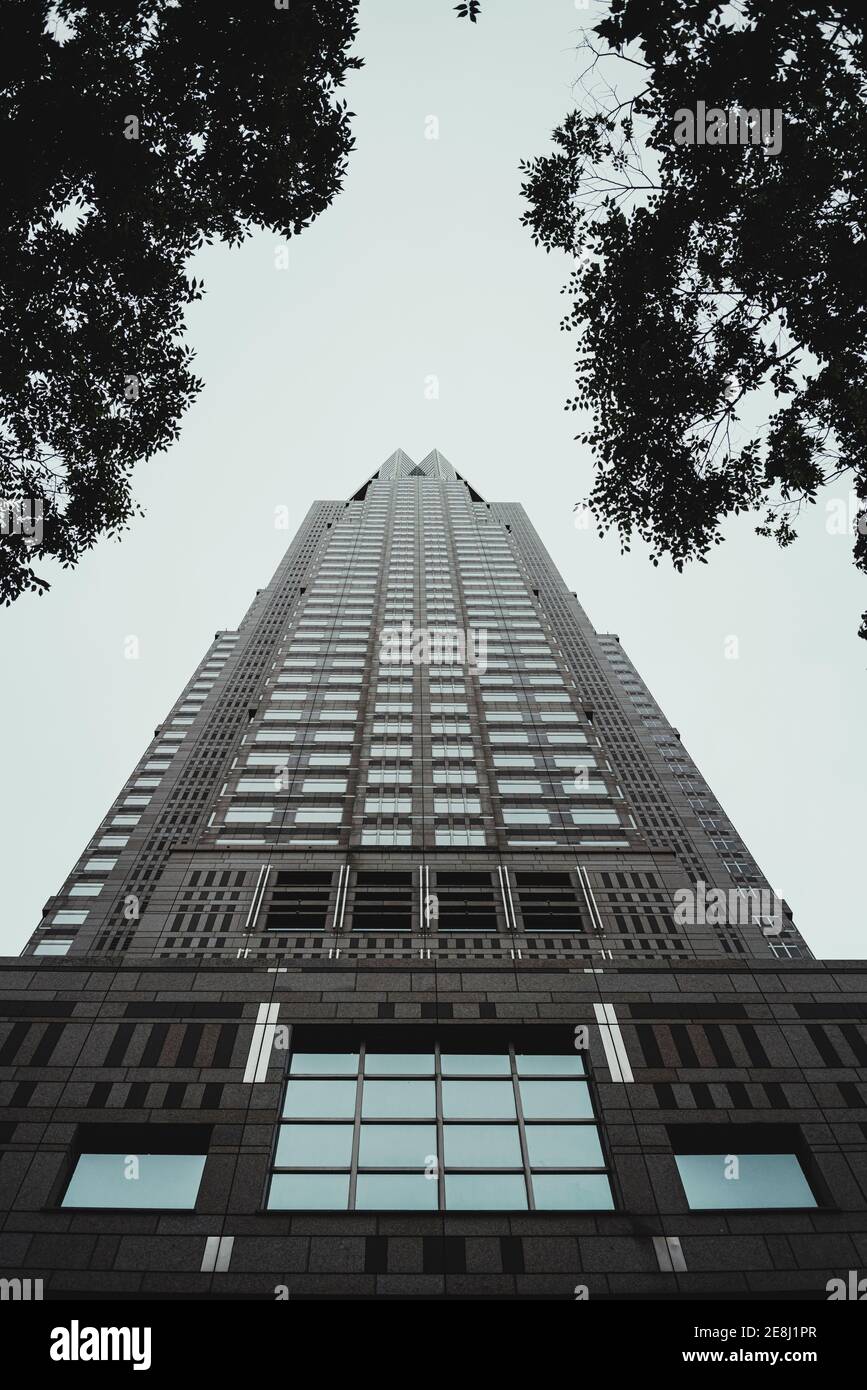 From below view to high skyscrapers towers and small buildings in big ...