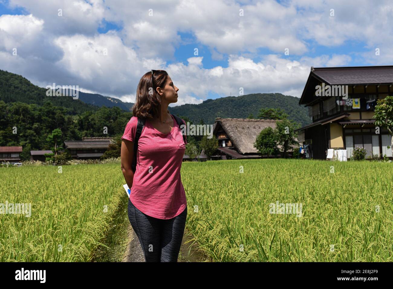 Young caucasian Woman in an open field in historical Japanese village ...