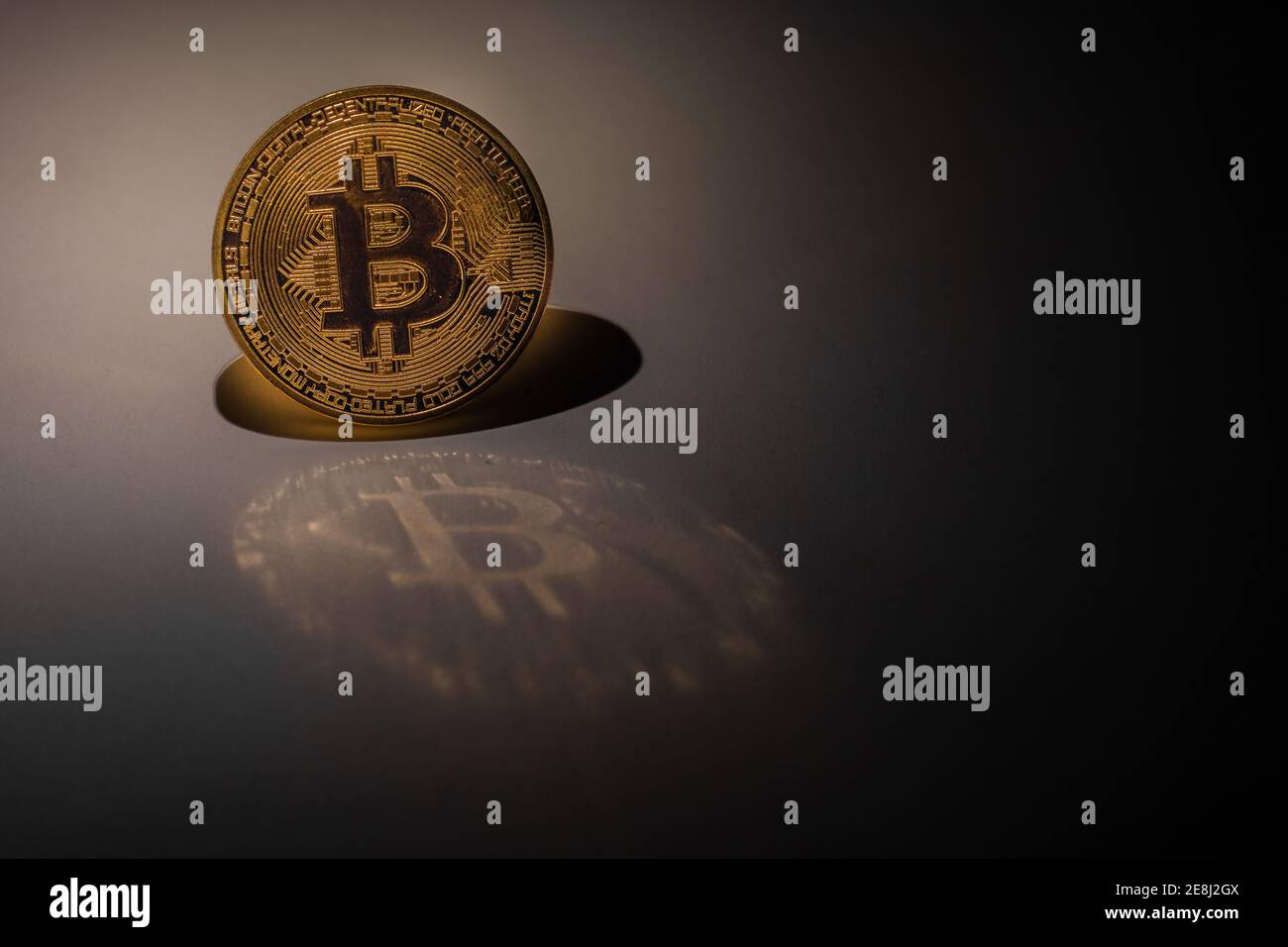 golden bitcoin illuminated with dark background shadow and reflection ...