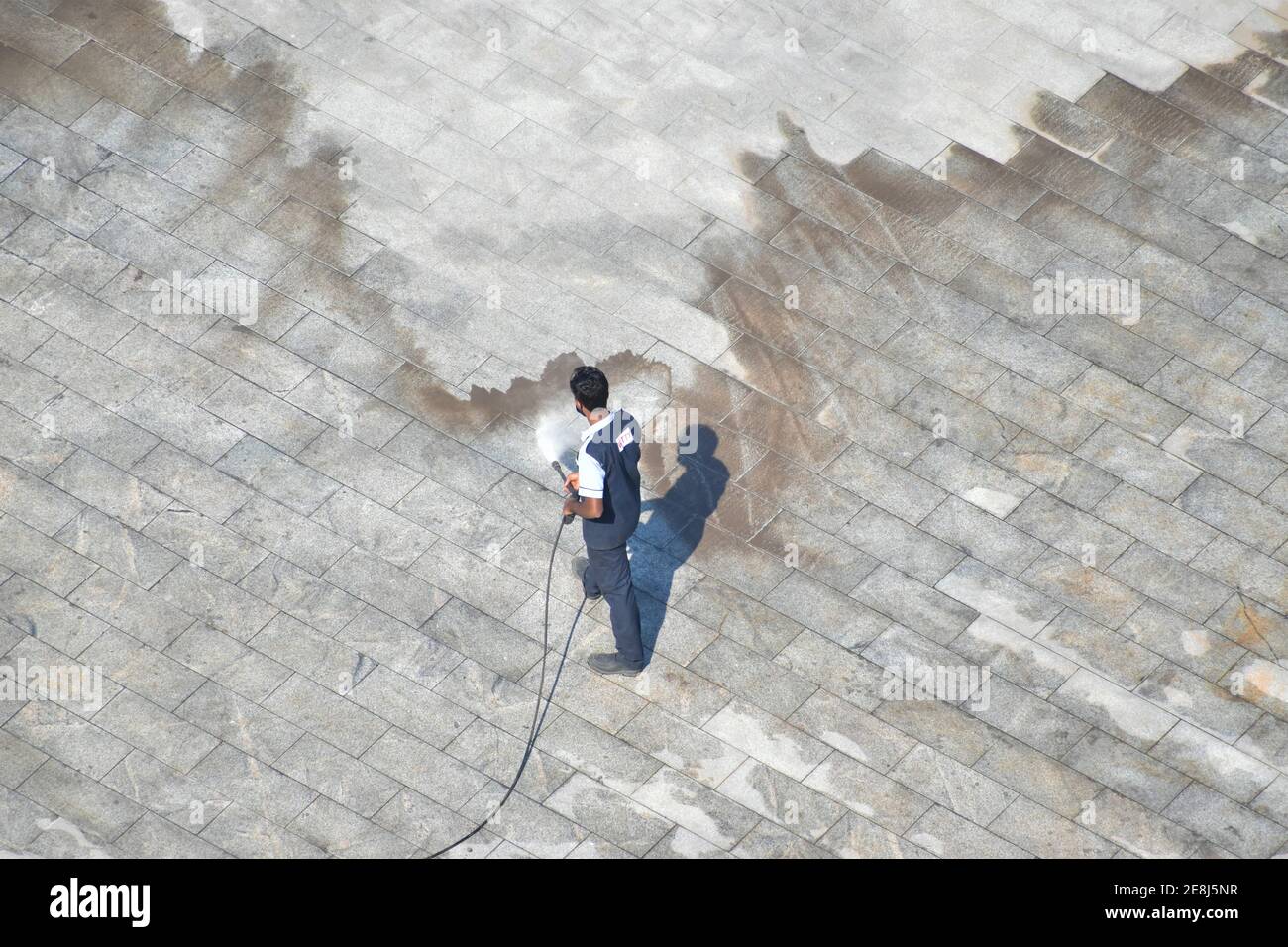 man cleaning floor with high pressure water jet spray Stock Photo - Alamy