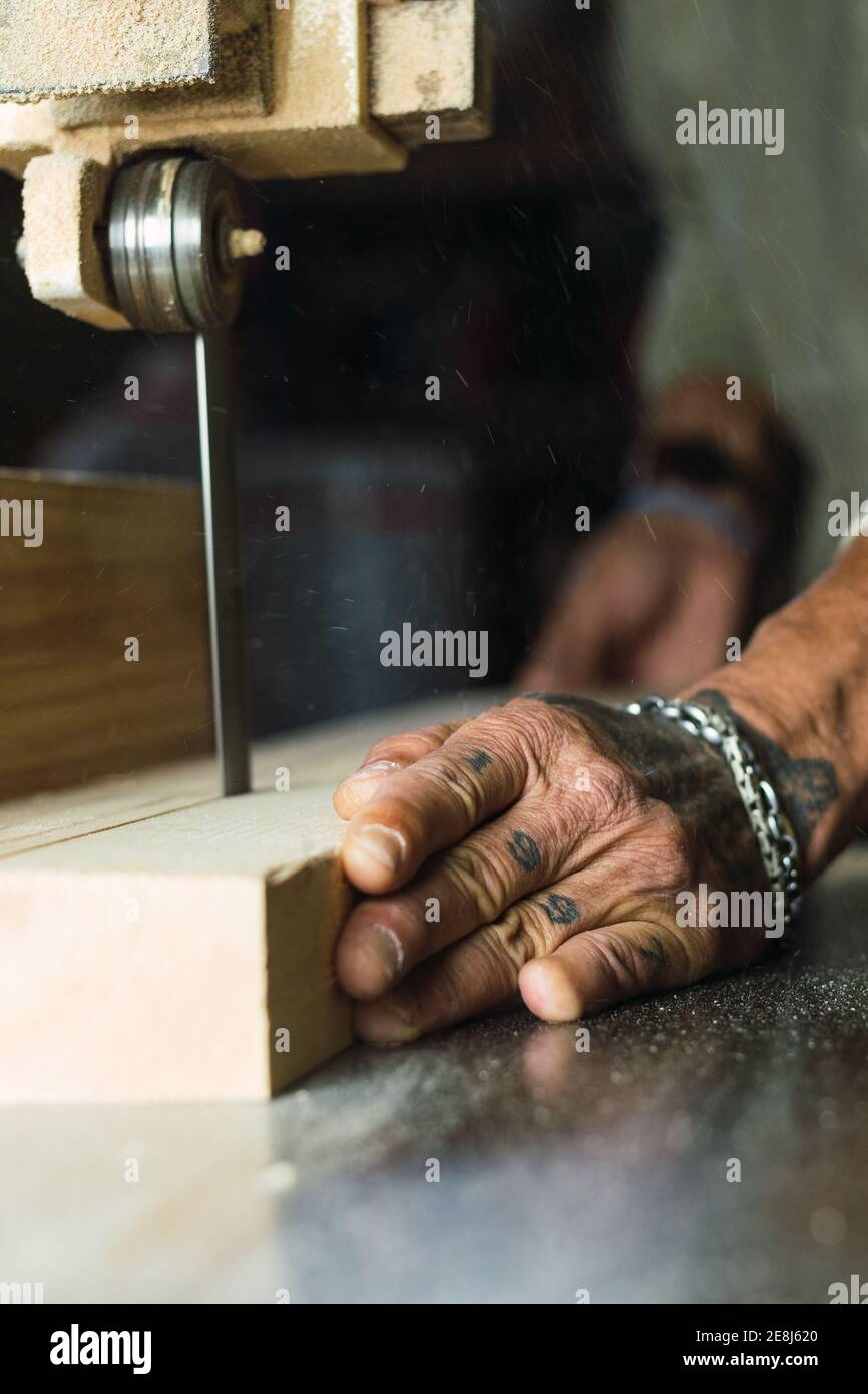 Cropped unrecognizable male carpenter without a thumb cutting piece of ...