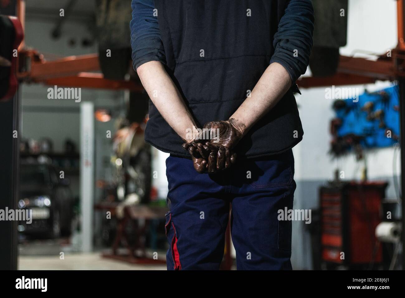 Back view of crop unrecognizable male auto mechanic in work wear with ...