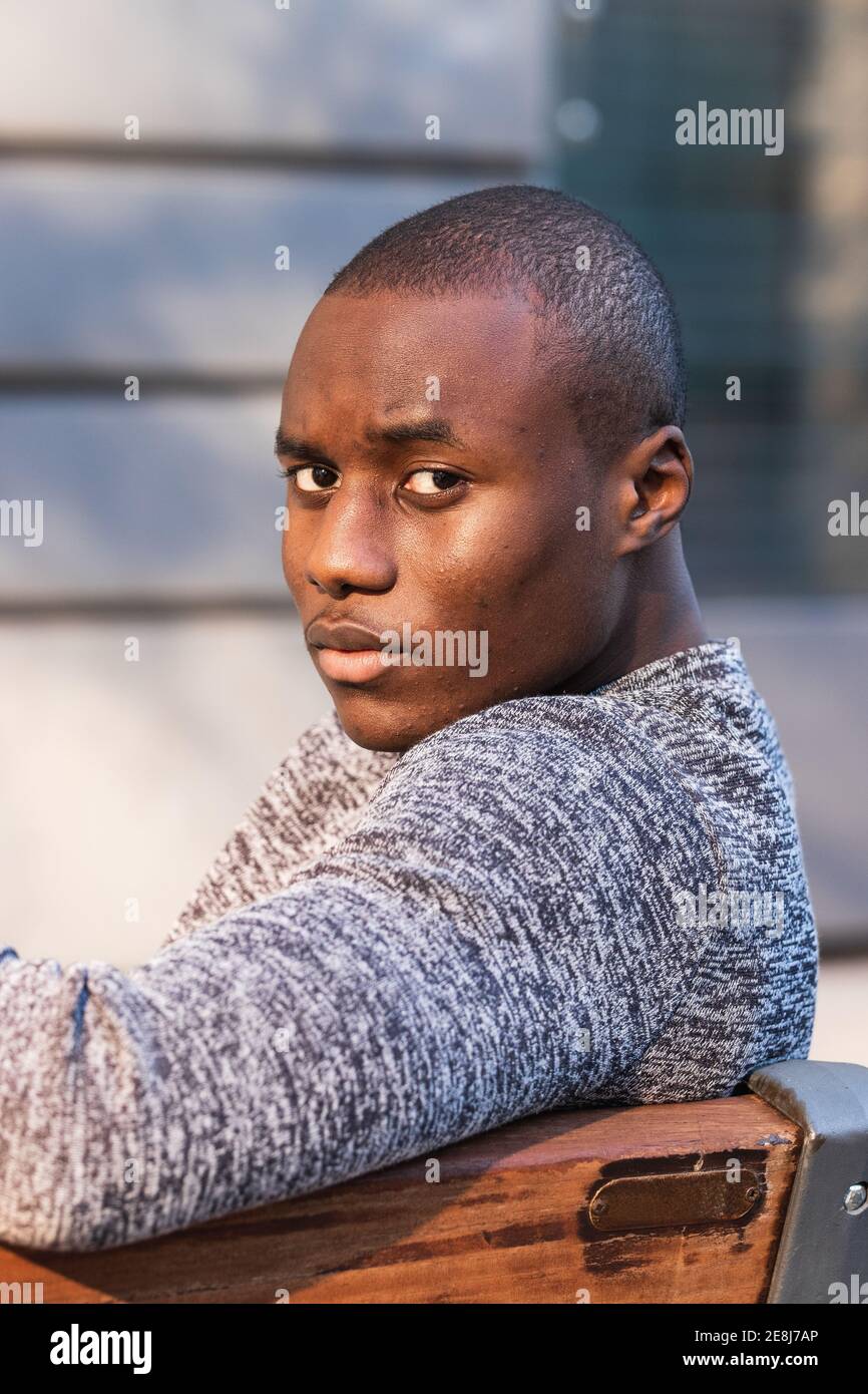 Side view of young African American male in casual wear looking at ...