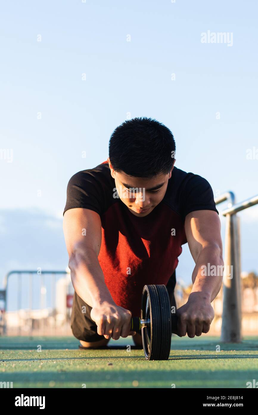 Full length of unrecognizable strong sporty male athlete exercising abs ...