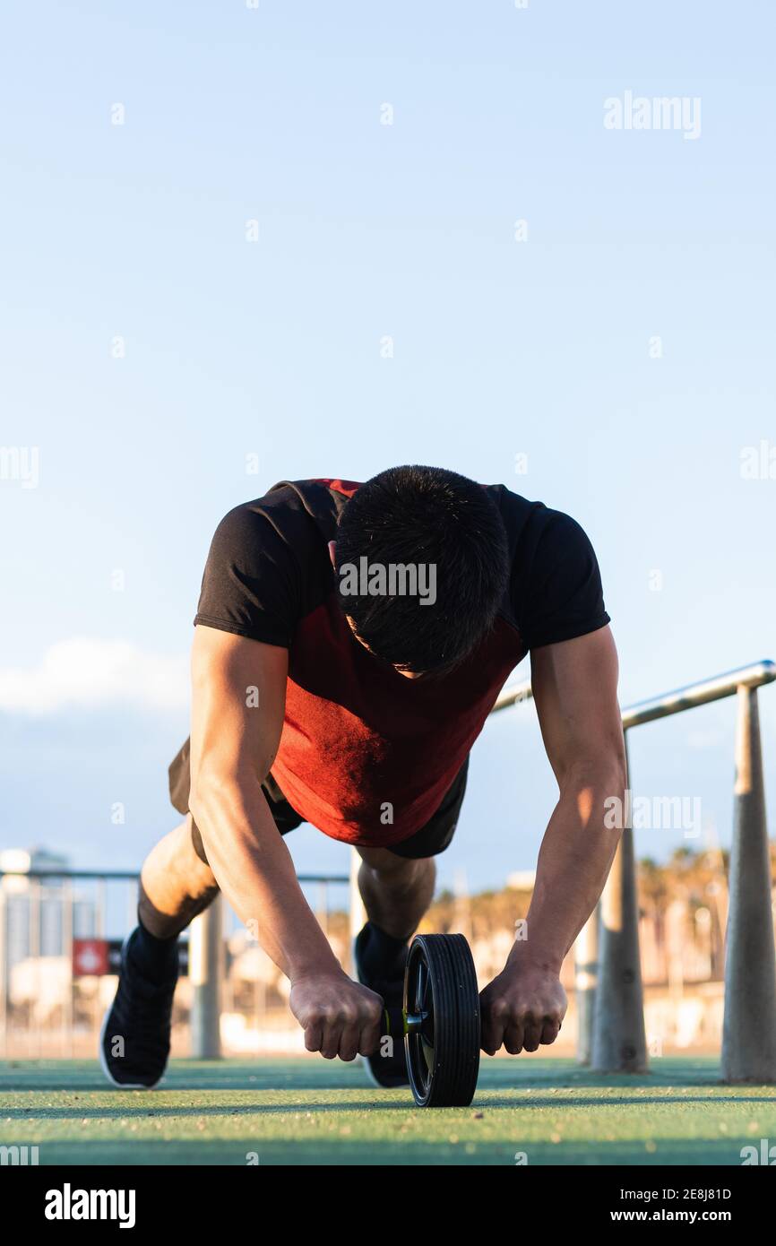 Full length of unrecognizable strong sporty male athlete exercising abs ...