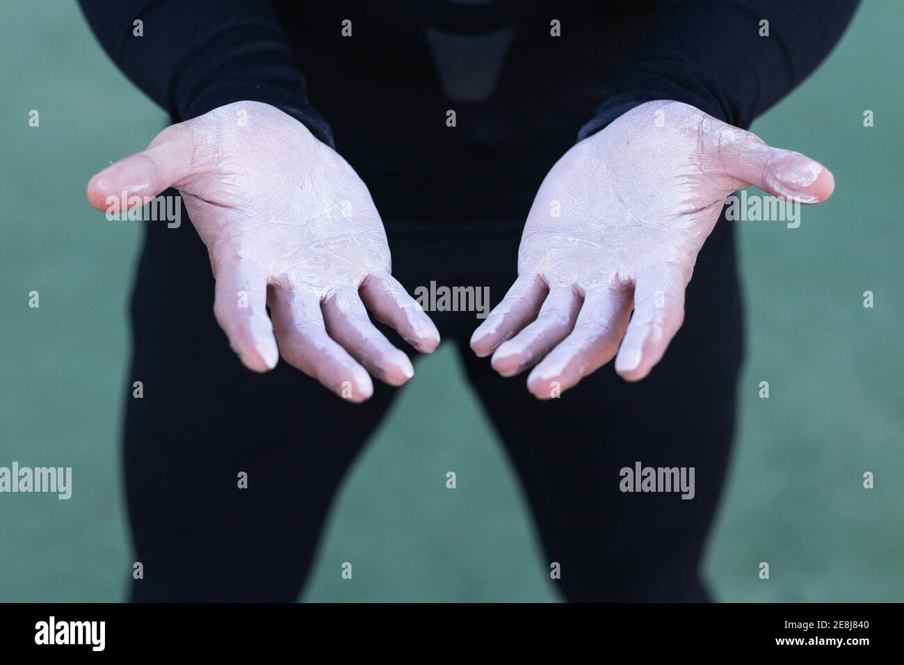 Crop anonymous athlete in black sportswear demonstrating hands covered ...