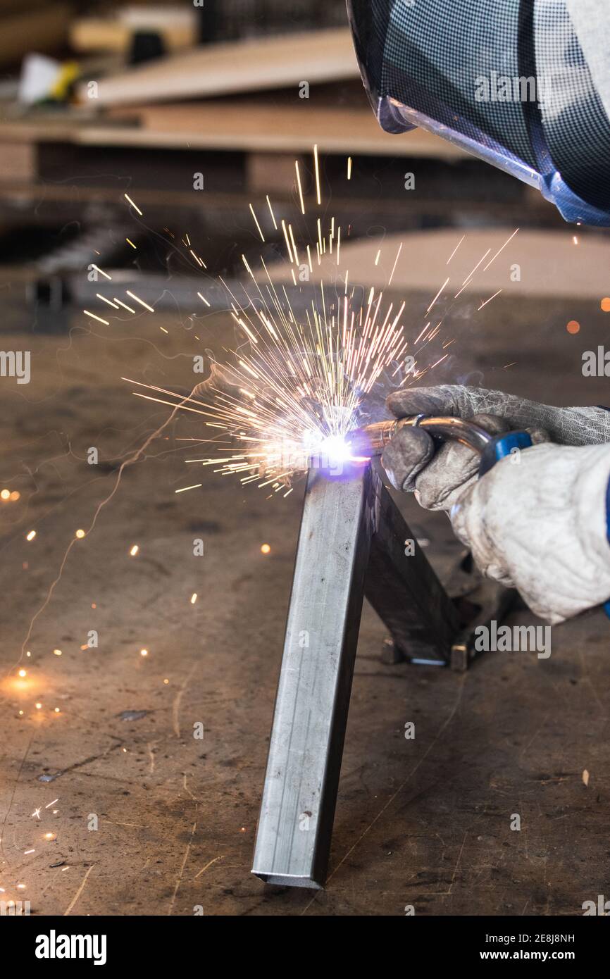 From above of crop unrecognizable welder in protective gloves welding ...