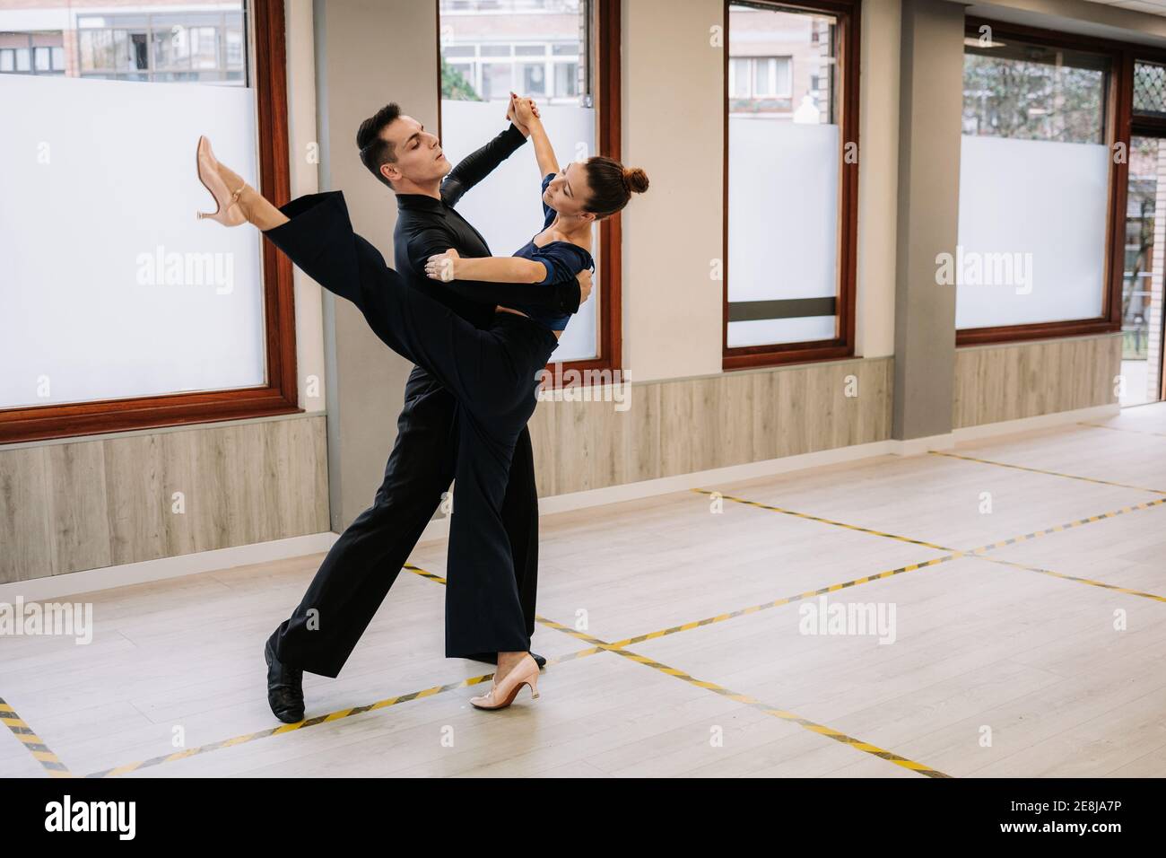 Skilled couple of dancers in elegant clothes rehearsing moves of ...