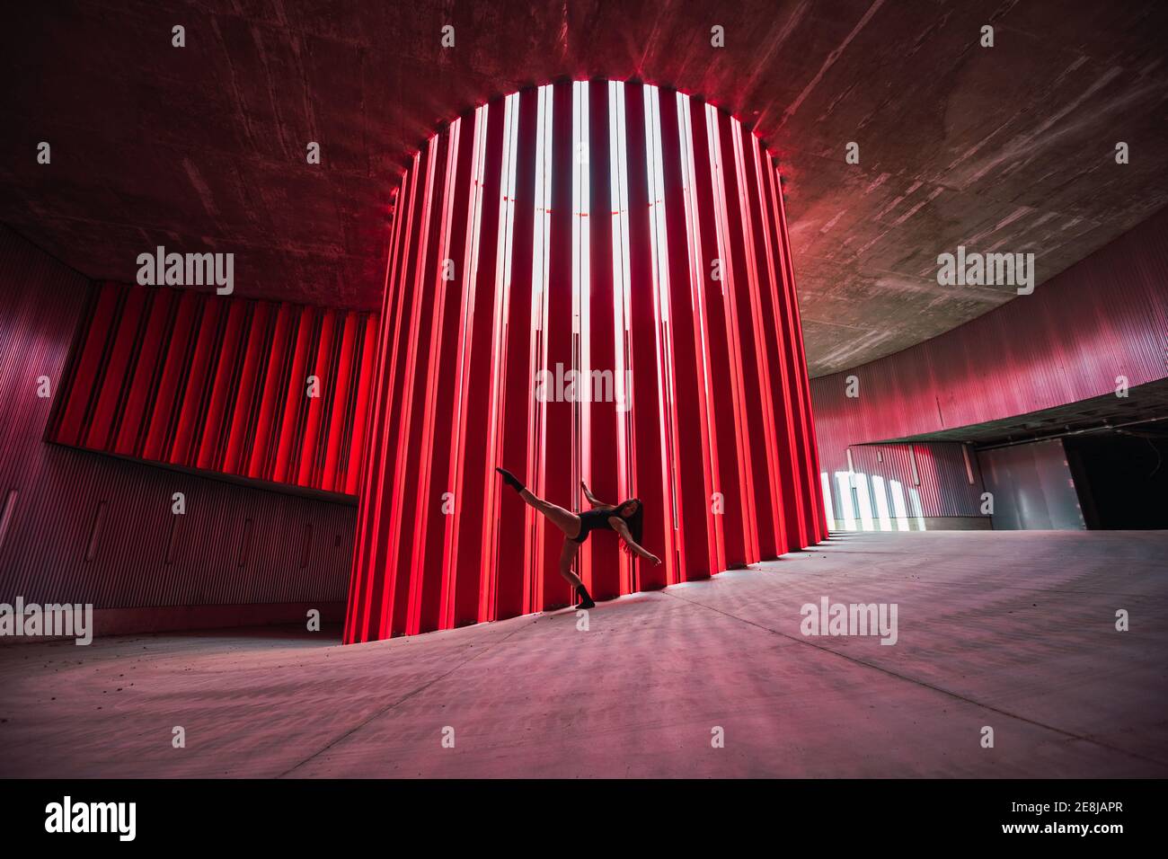 Side view of anonymous female theater artist stretching leg while ...