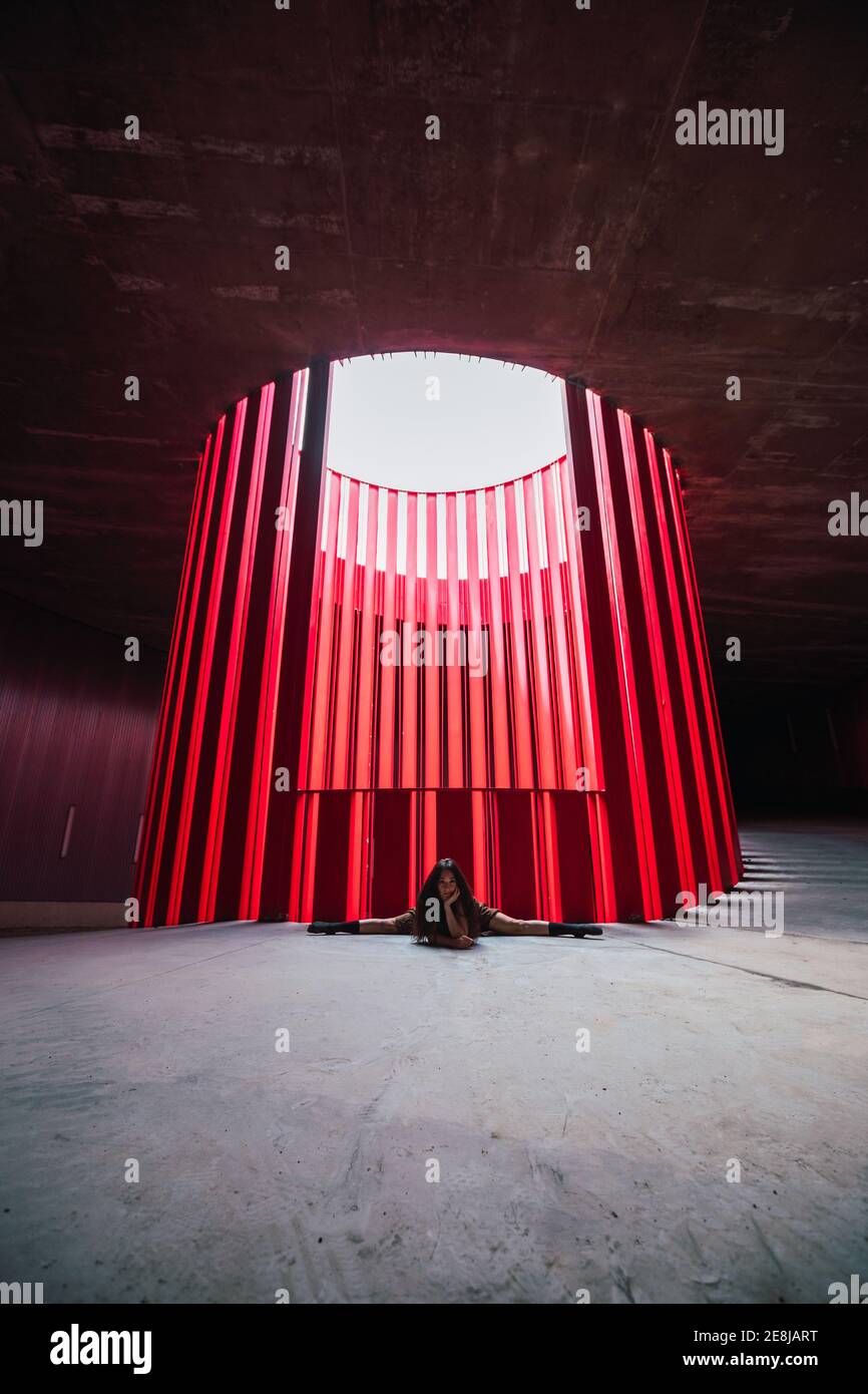 Anonymous flexible female dancer sitting in split while leaning on hand ...