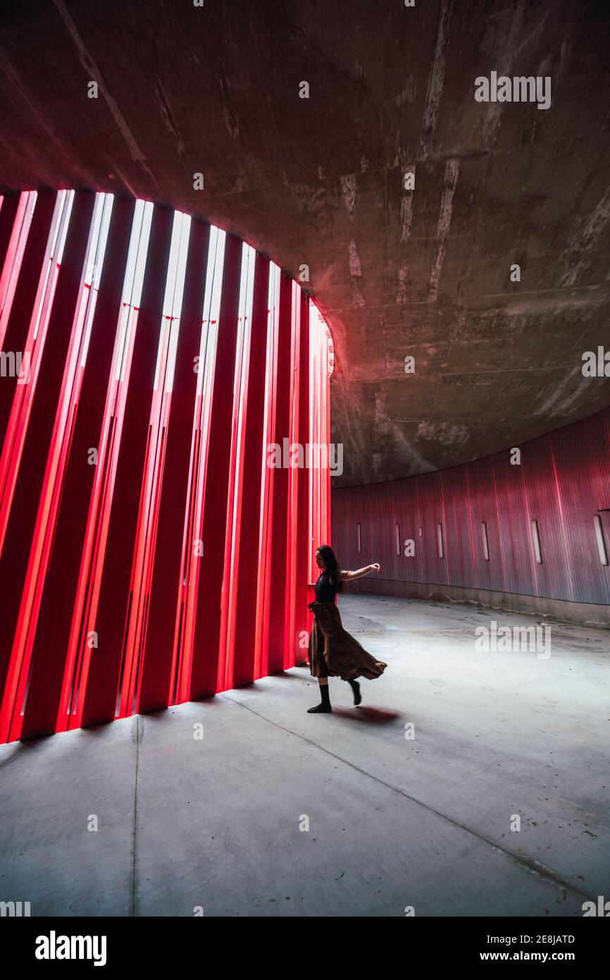 Side view of anonymous female theater artist stretching leg while ...