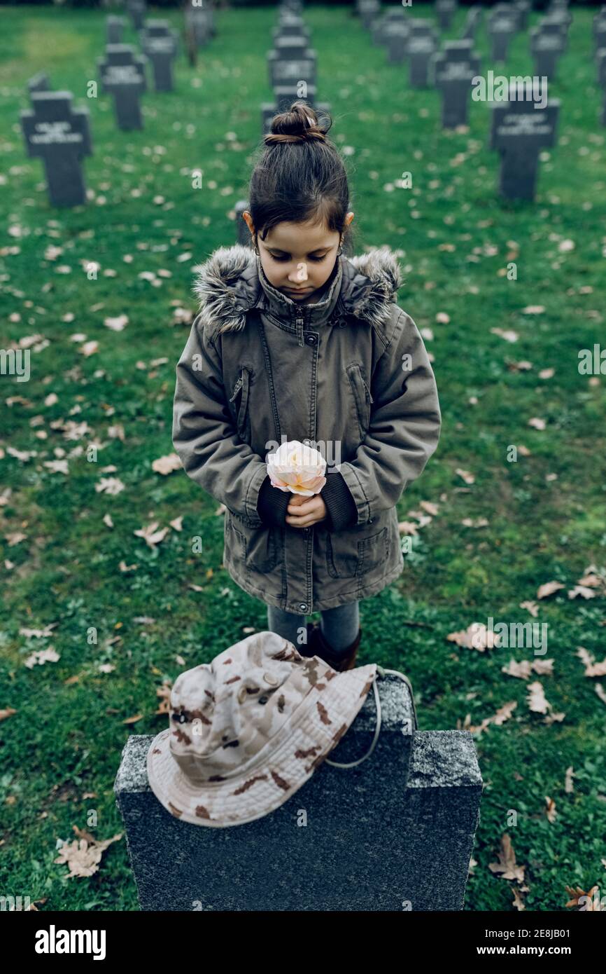 High angle of small kid mourning death of soldier fighting in war at ...