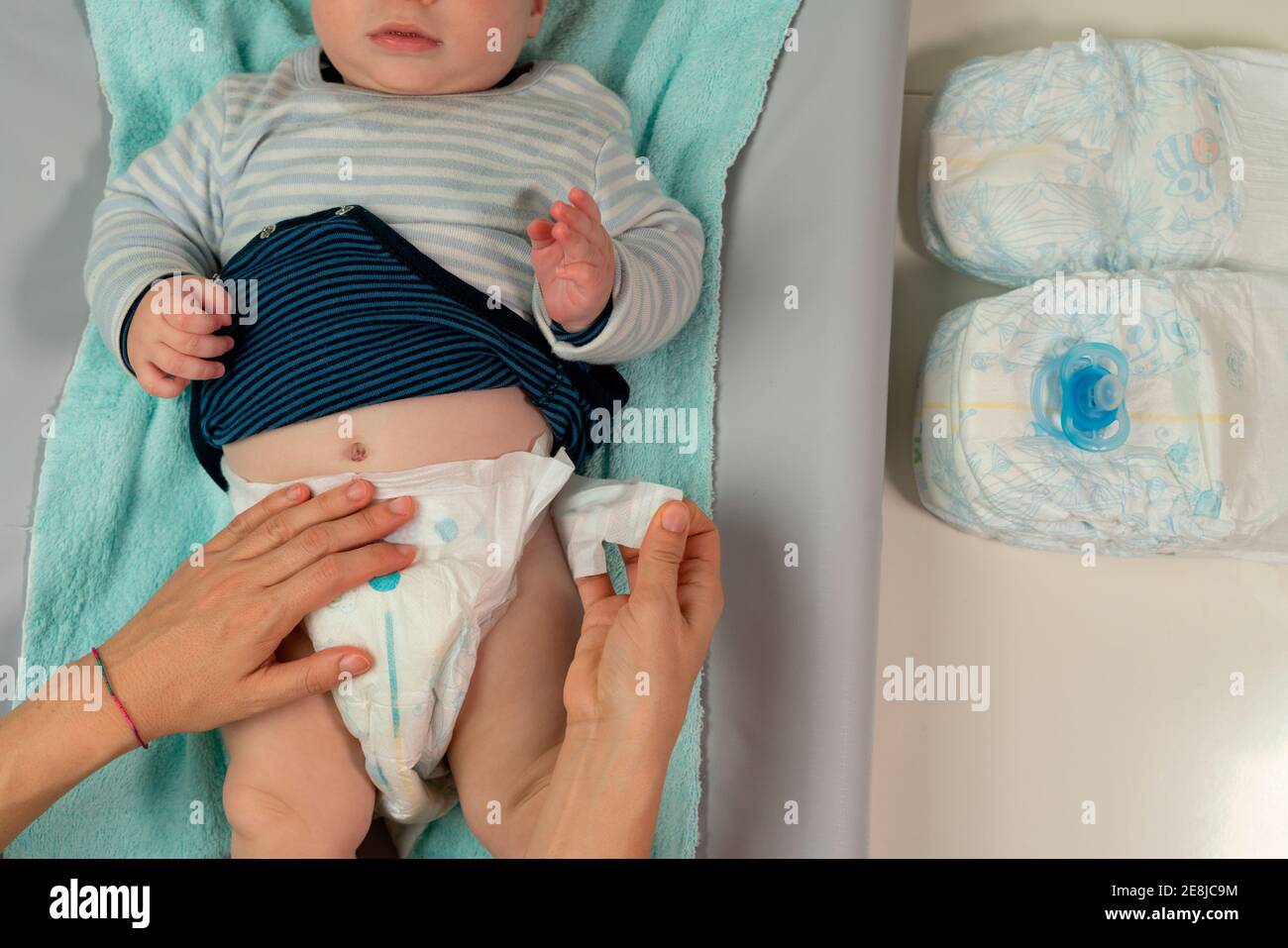Top view crop caring mom changing diaper on cute baby lying on changing ...