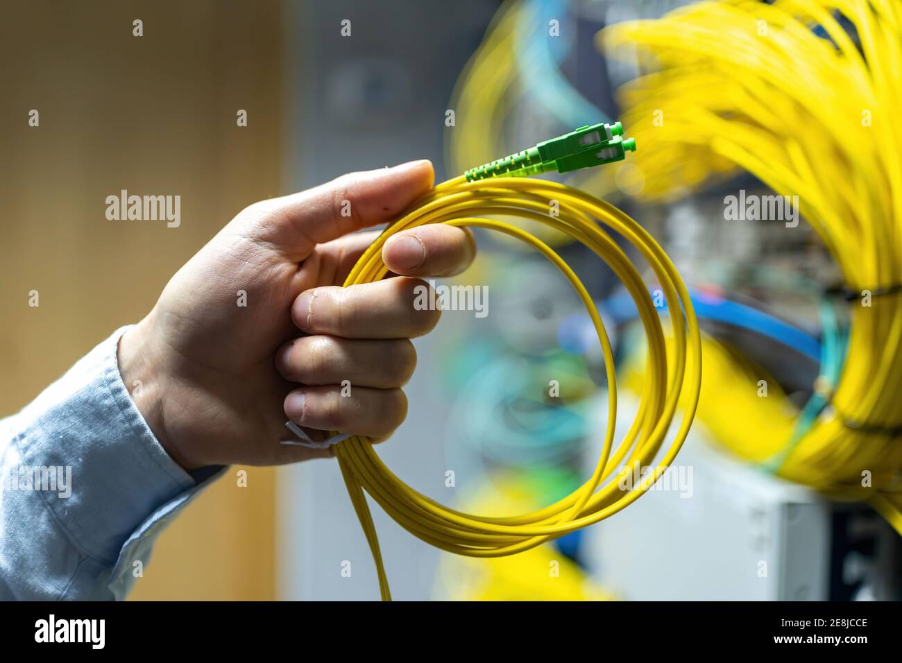 From below of crop anonymous man putting electronic cable in data ...