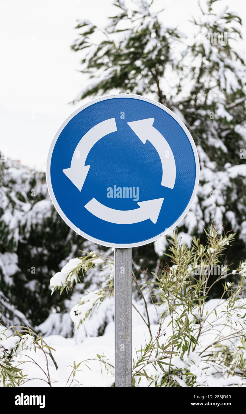 Blue road sign showing roundabout symbol near wavy pathway against ...