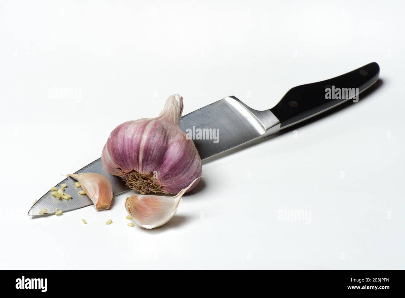 Garlic bulb and cloves of garlic on knife, Allium sativum Stock Photo ...