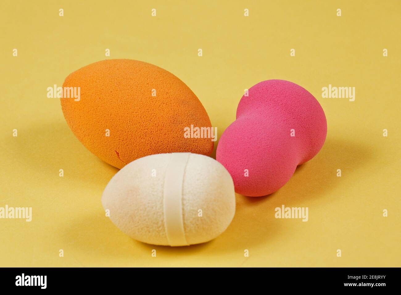 Colorful makeup foam sponges beauty tool accessory on yellow background ...