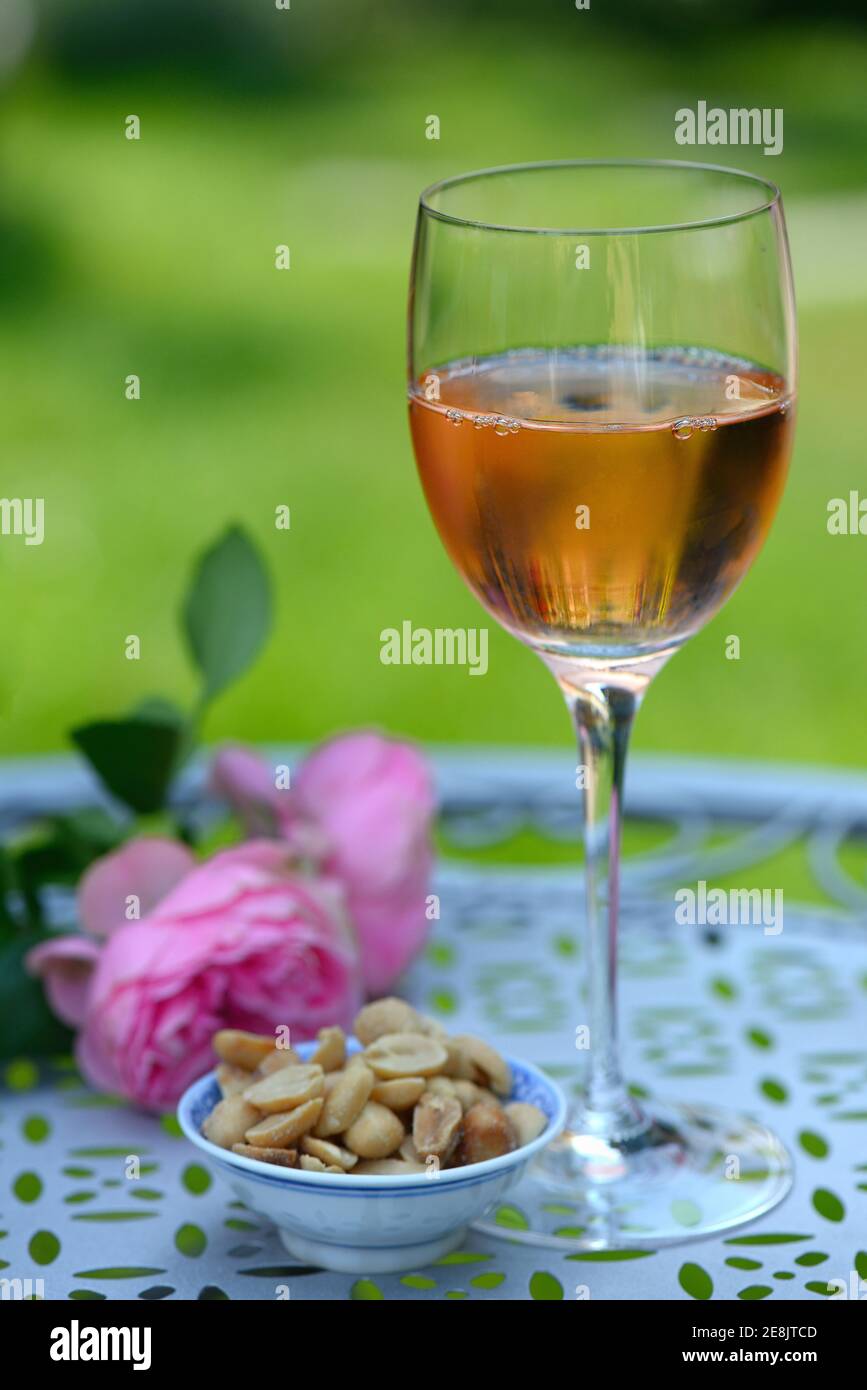 Glass of rose wine and small bowl with peanuts, rose wine Stock Photo ...