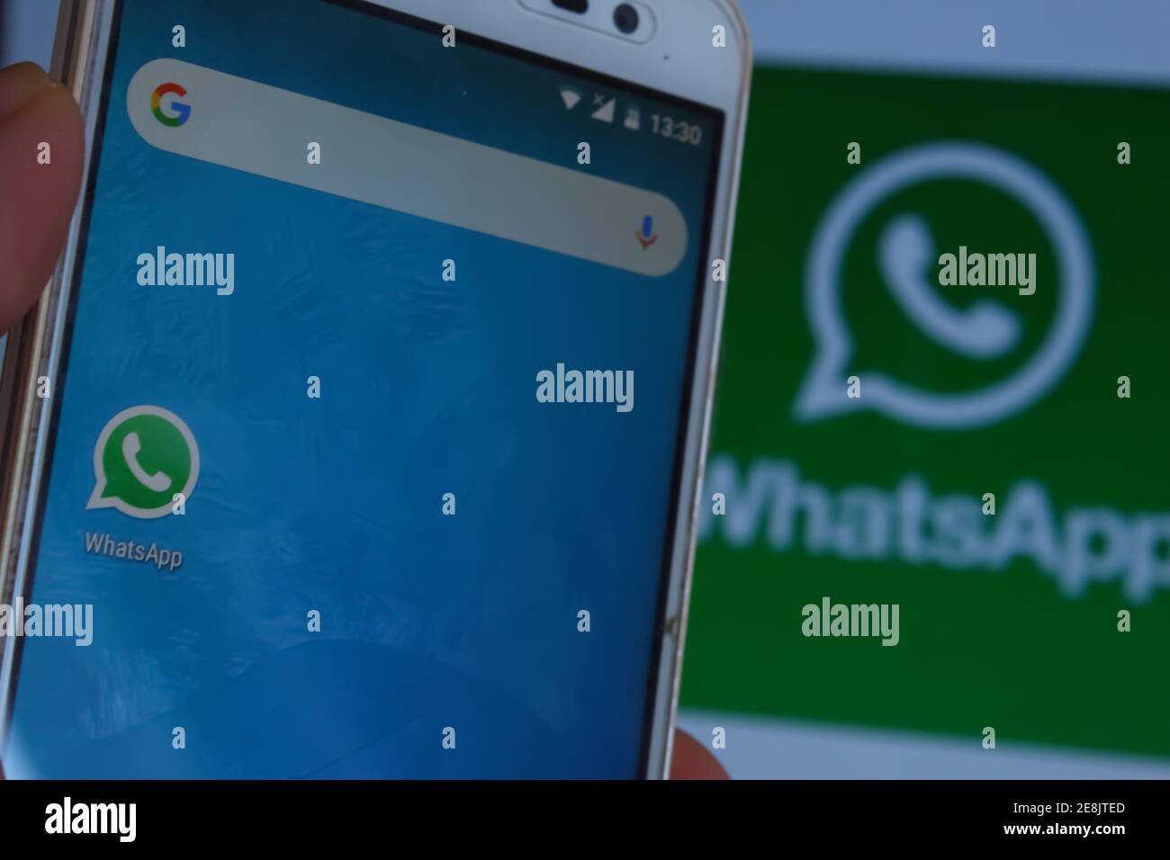 Close up man hand holding the phone with whatsapp logo on his screen ...