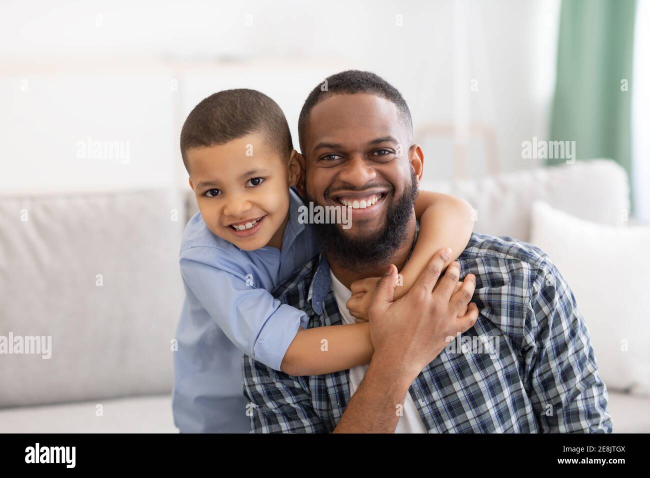 Portrait Of Cheerful African Father And Son Hugging At Home Stock Photo ...