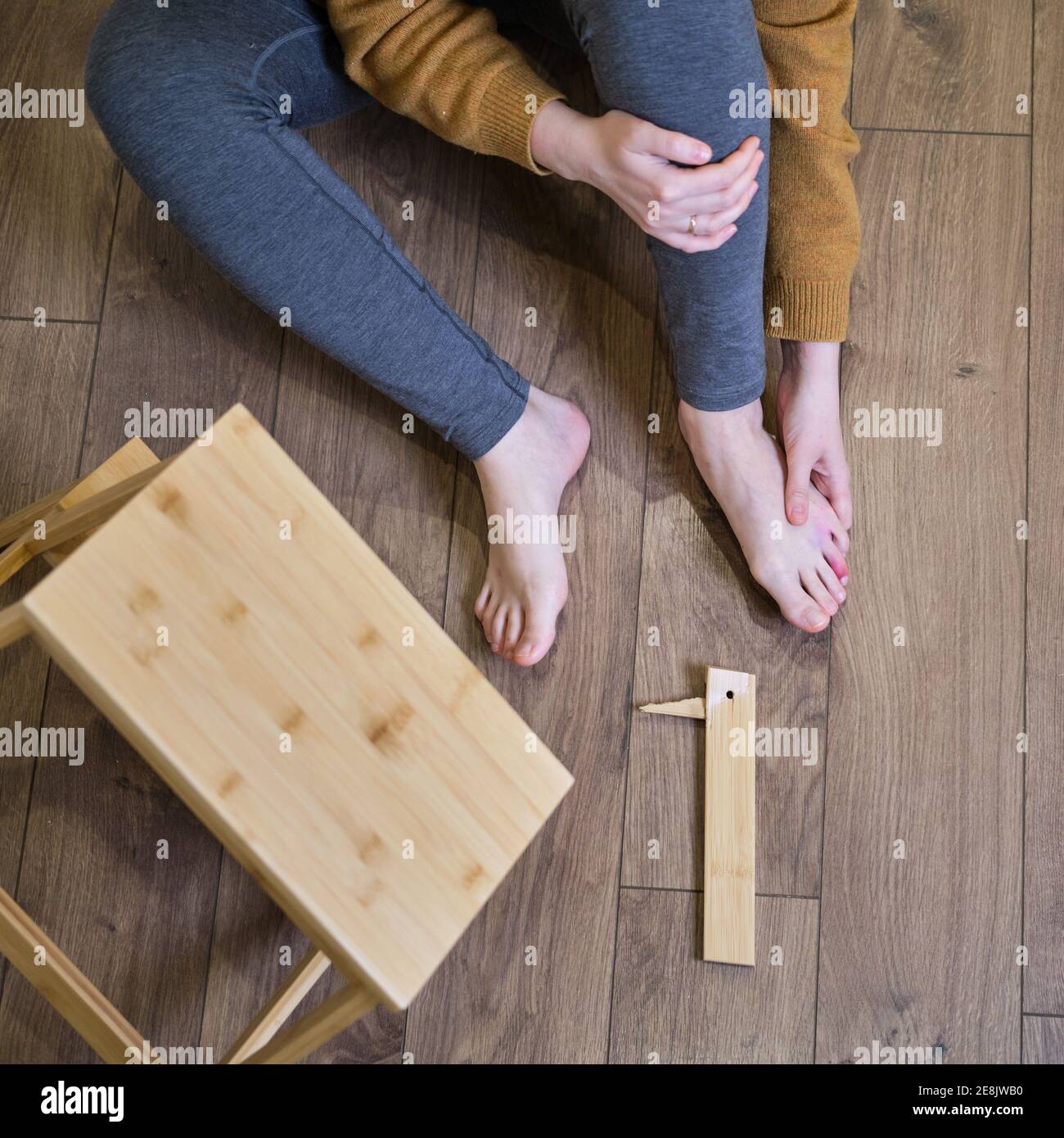 A woman fell from a wooden stepladder and holds on to her sore leg ...