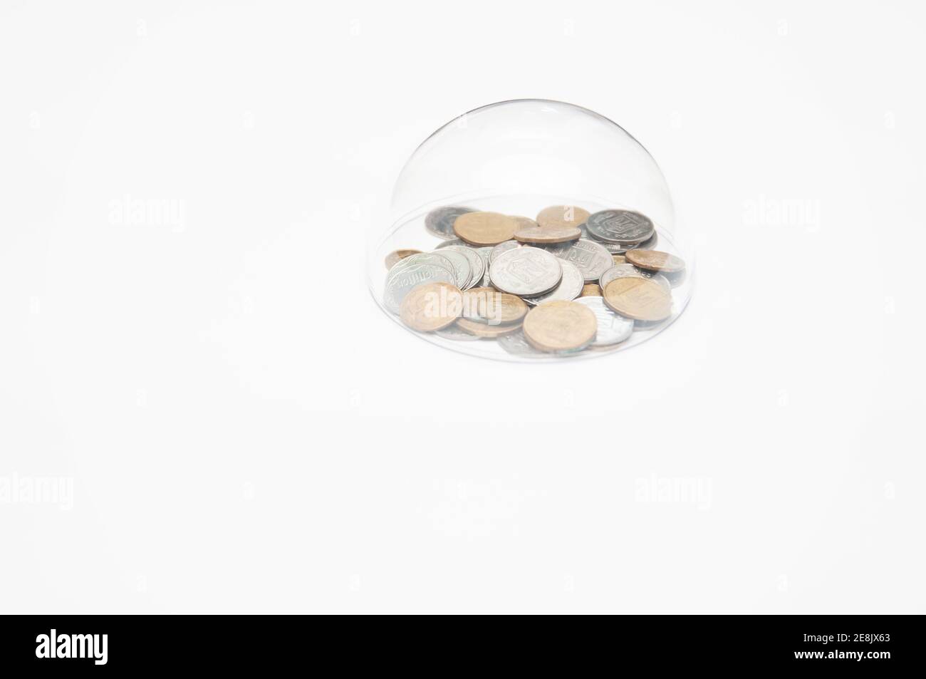 metal coins are grouped under a glass semicircle on a white background ...