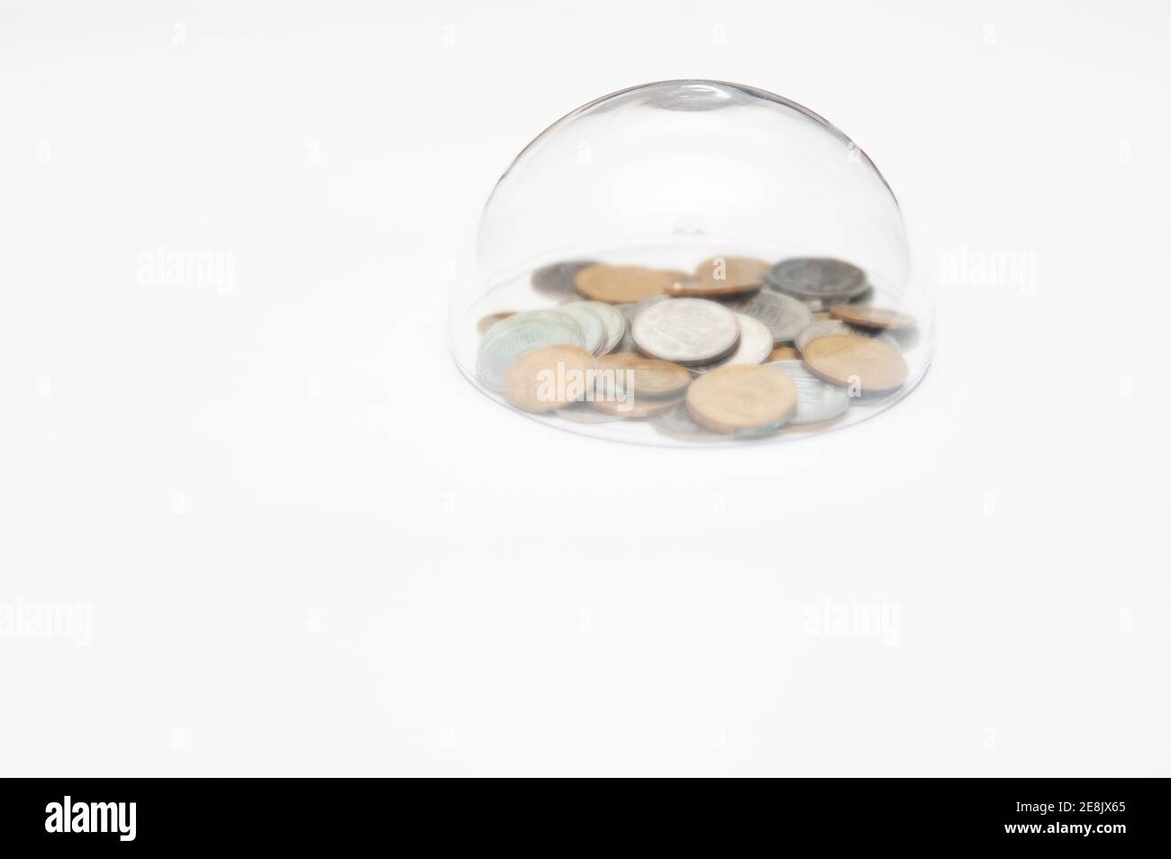 metal coins are grouped under a glass semicircle on a white background ...