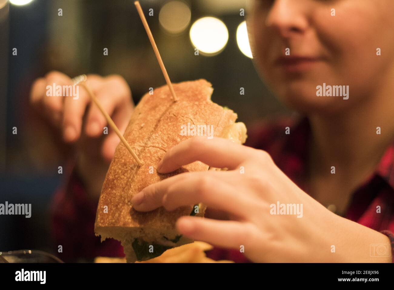 A young woman eating a sandwich in a restaurant Stock Photo - Alamy