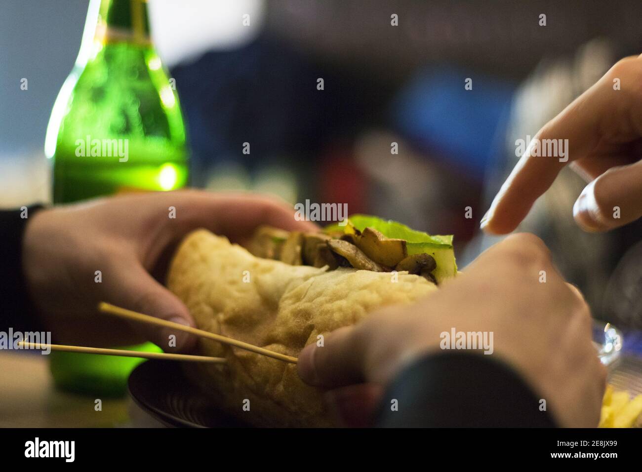 The hands of a person grabbing a sandwich in a restaurant Stock Photo ...