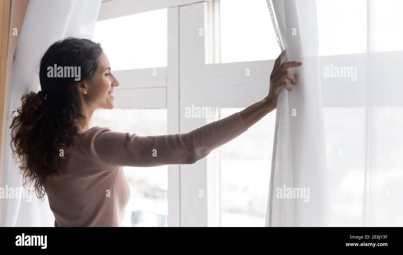 Woman opening curtains hi-res stock photography and images - Alamy