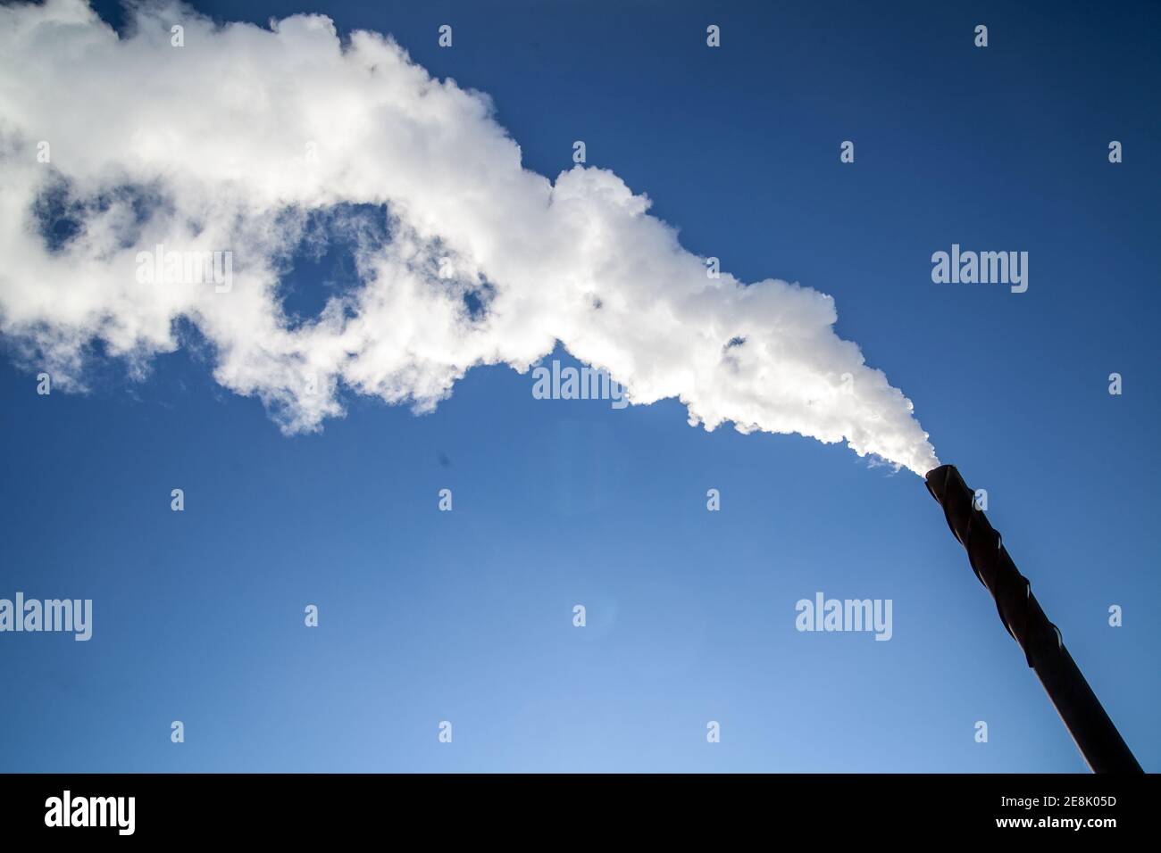 A long cloud of white smoke escaping from a metallic chimney against a ...