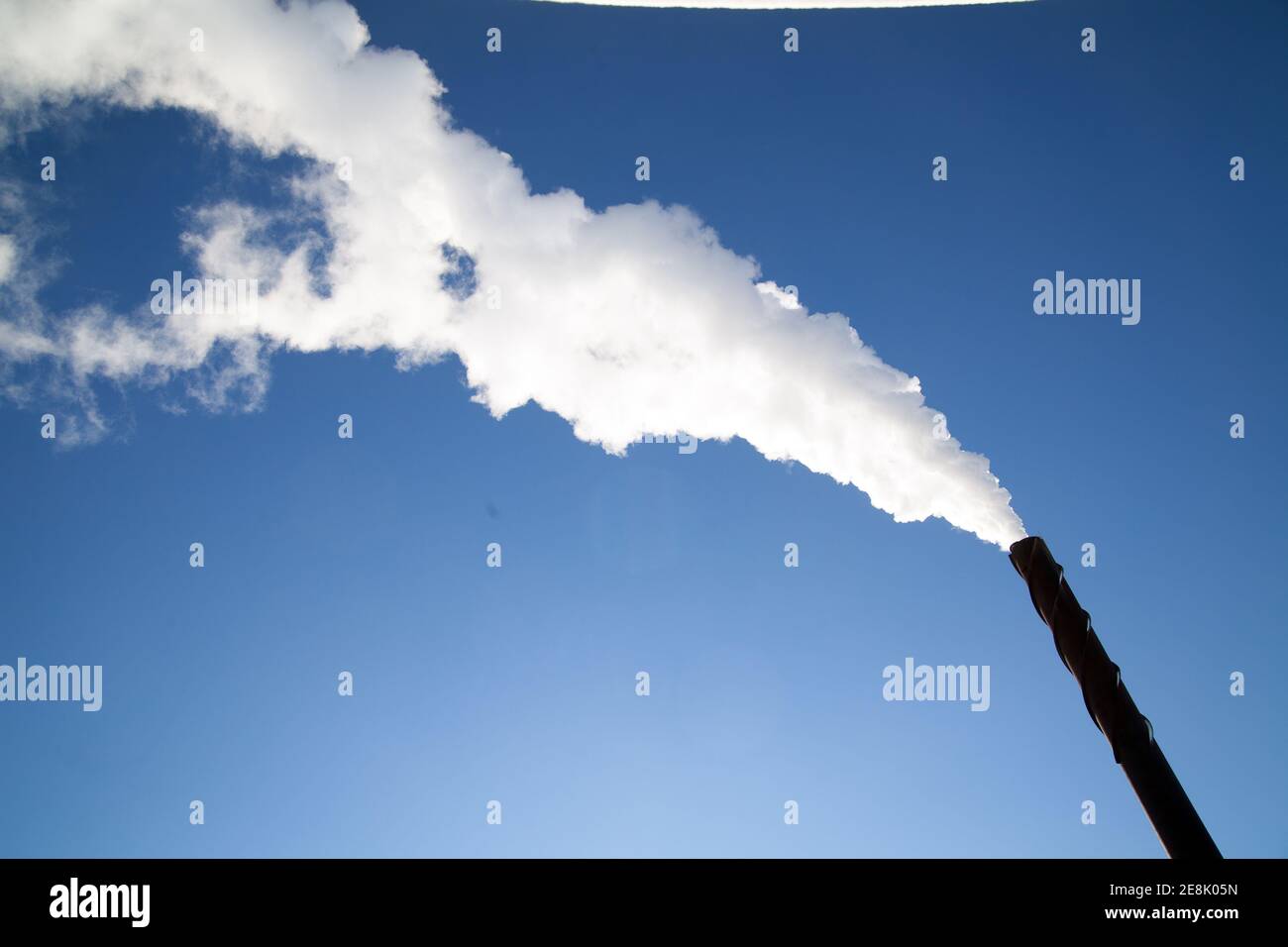 A long cloud of white smoke escaping from a metallic chimney against a ...