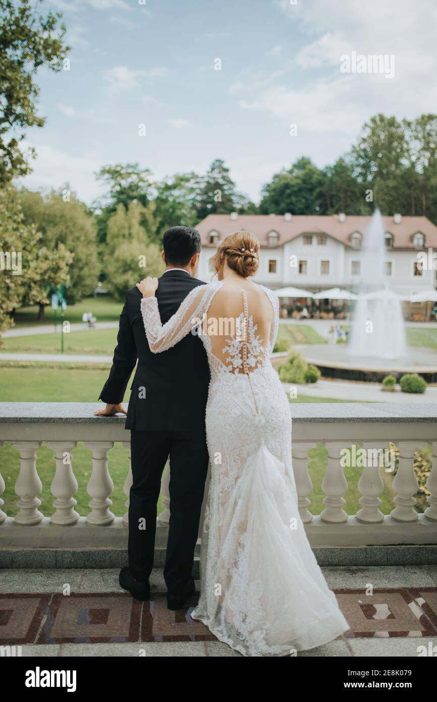 a vertical shot of a bride and bridegroom from the back looking from a ...