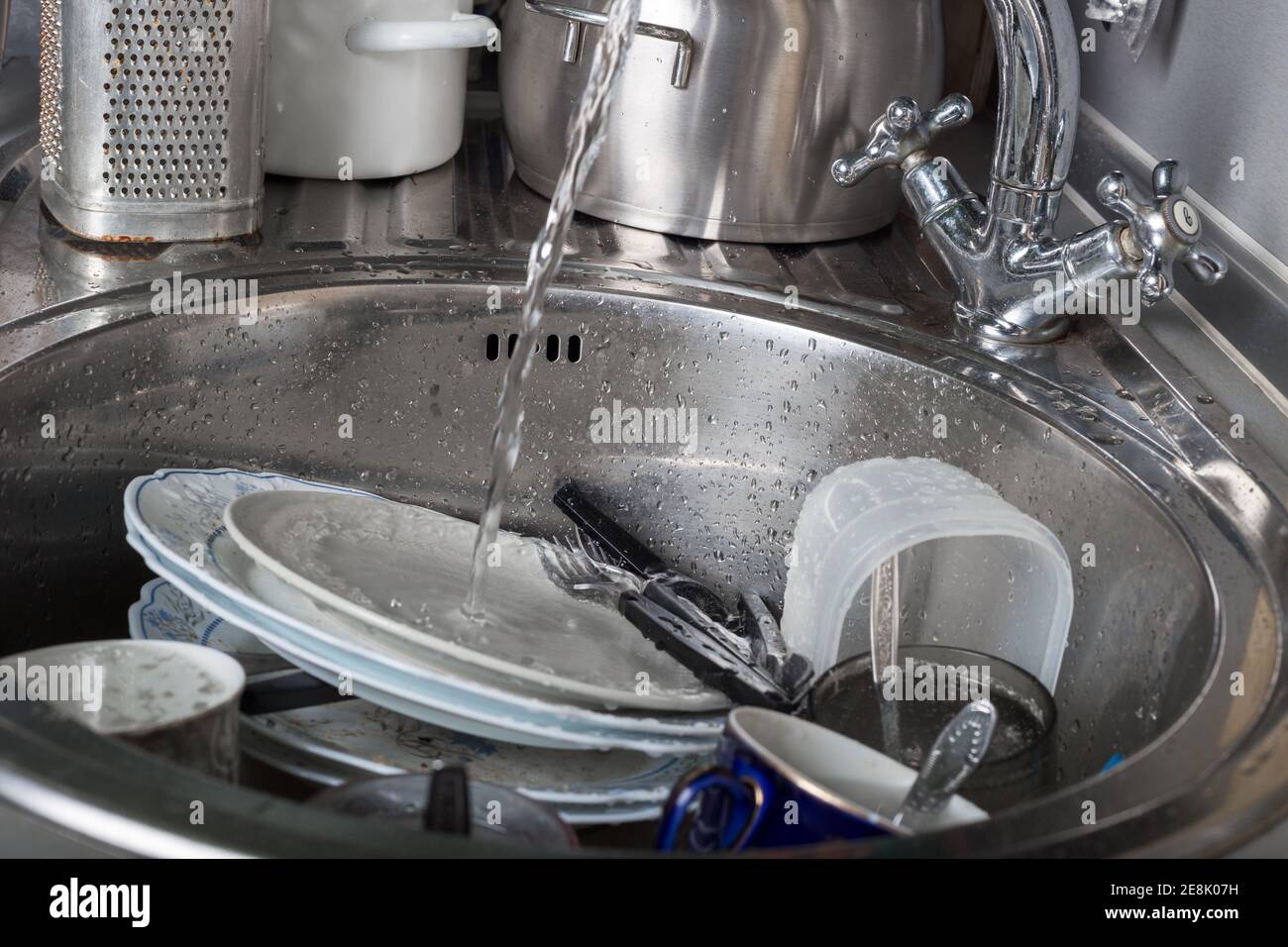 Unwashed dishes and utensils in kitchen sink Stock Photo - Alamy
