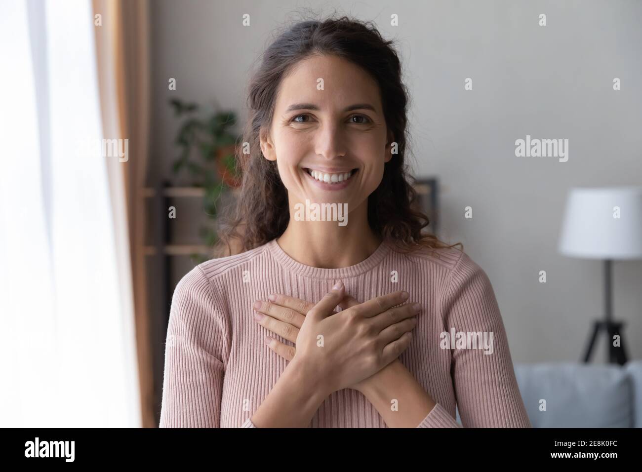 Portrait of happy female volunteer holding folded hands on chest Stock ...